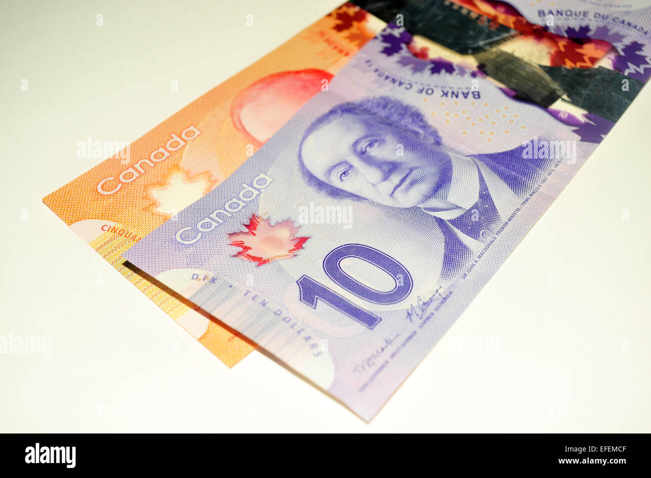 Canadian $50 and $10 currency notes photographed against a white ...
