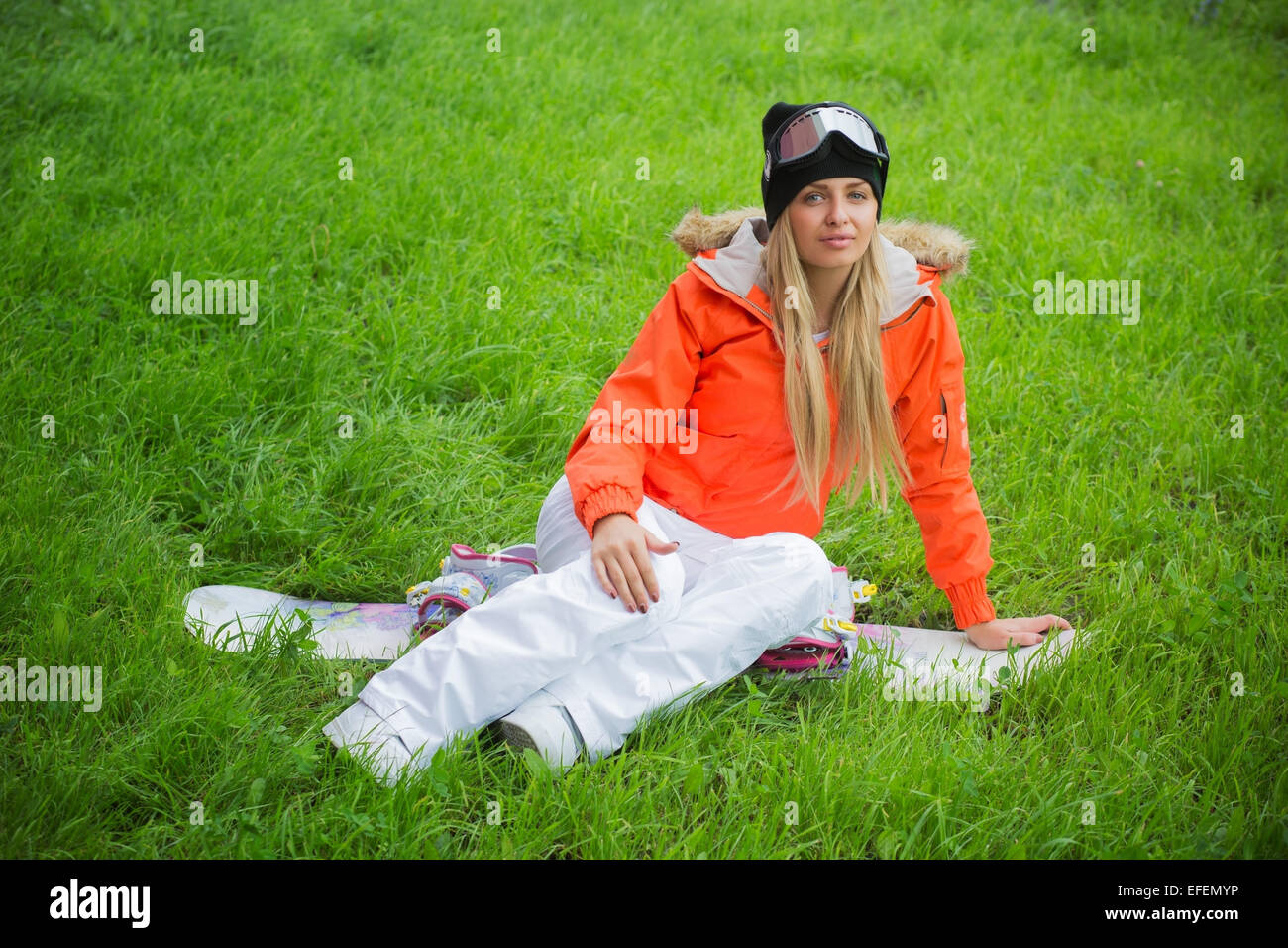 girl with a snowboard is sitting on the grass Stock Photo - Alamy