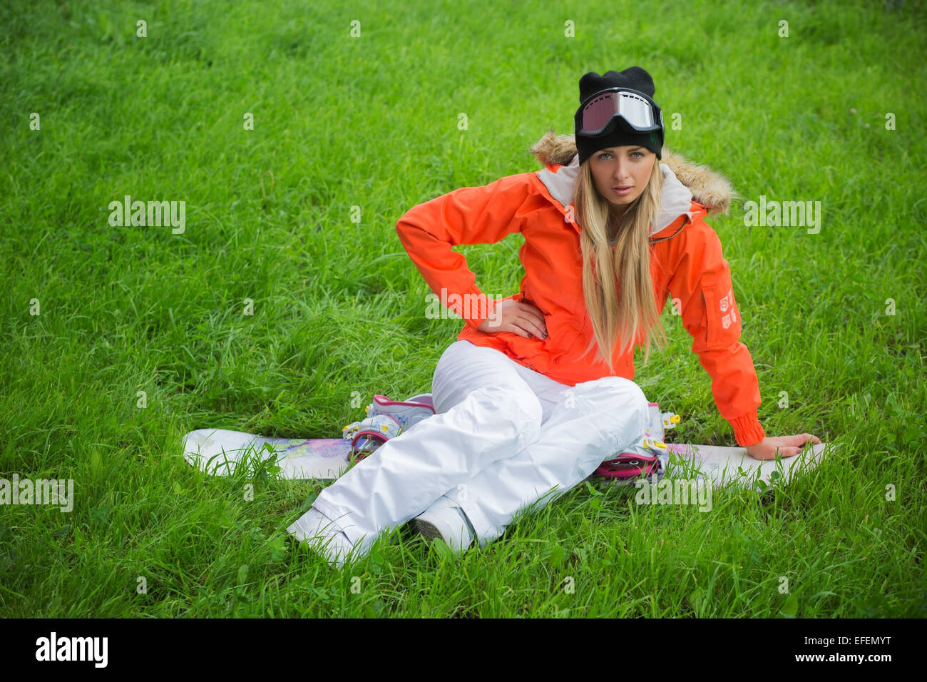 girl with a snowboard is sitting on the grass Stock Photo - Alamy