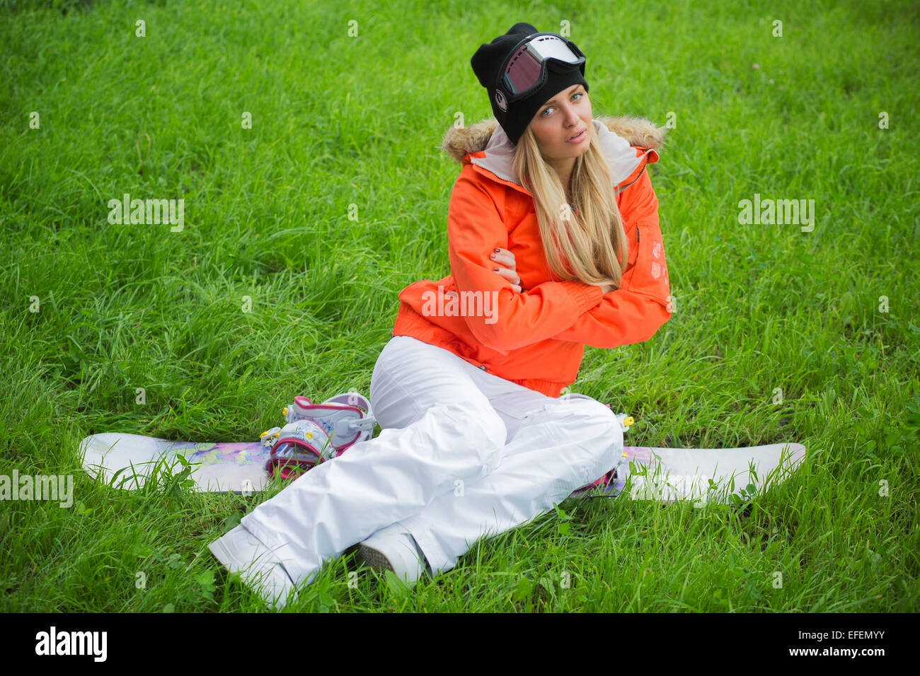 girl with a snowboard is sitting on the grass Stock Photo - Alamy