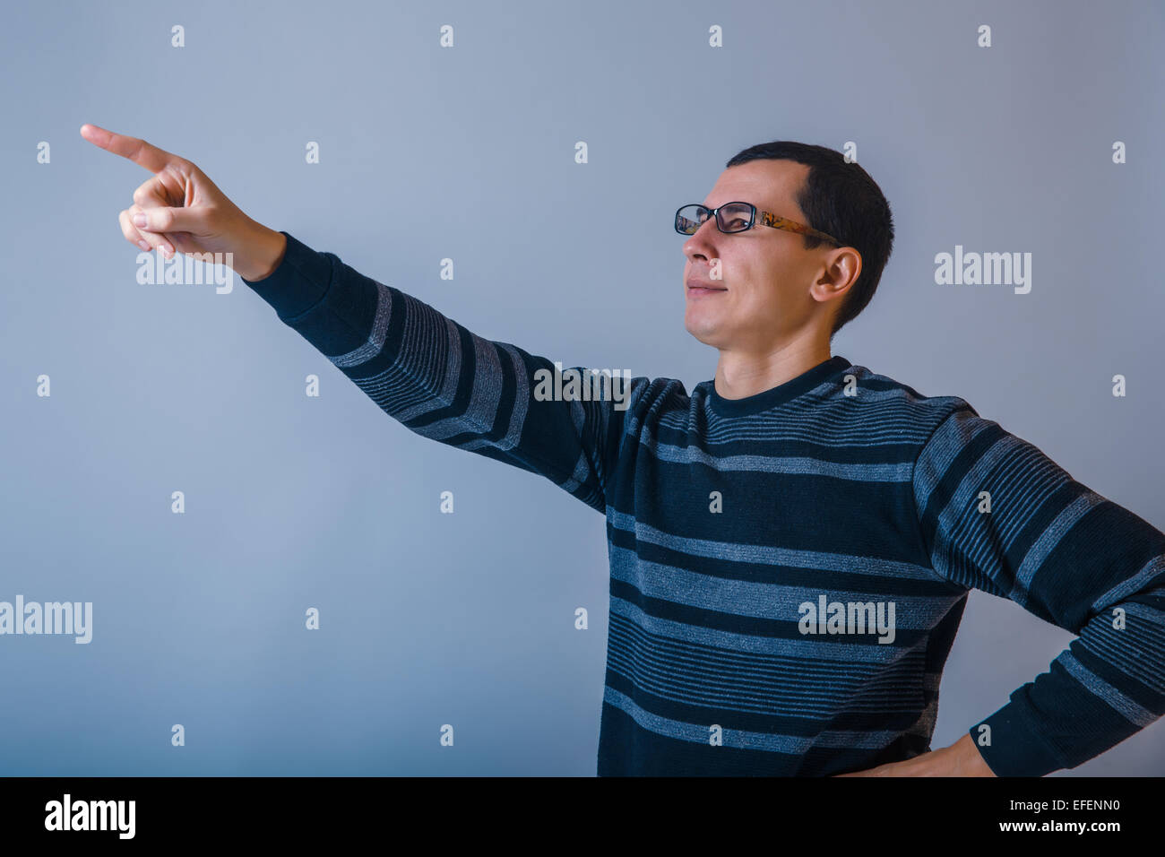 European-looking male of about thirty points a finger upward on Stock ...