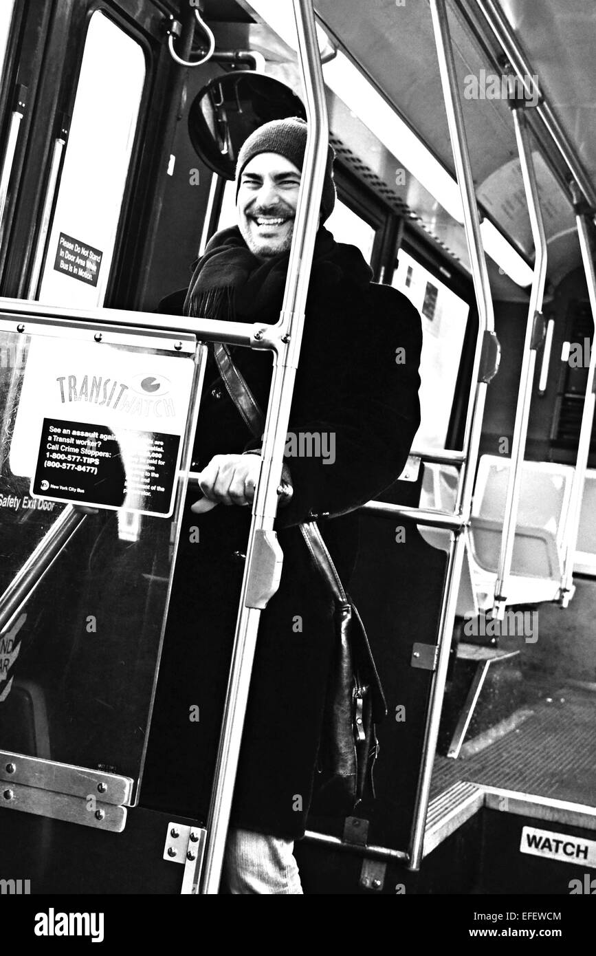 Man on bus laughing while standing up in BW Stock Photo - Alamy