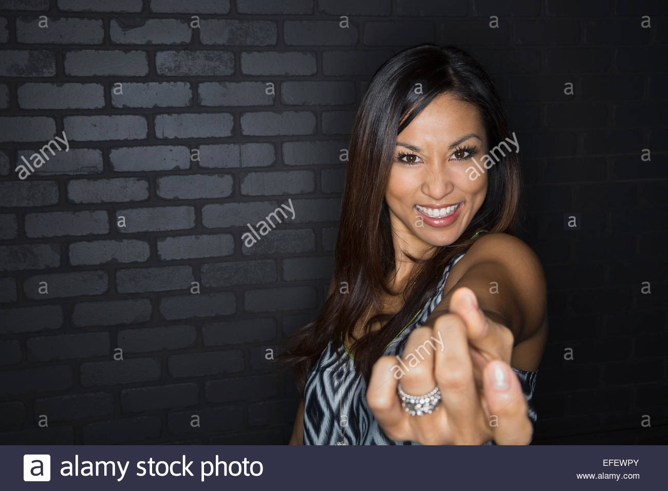 Portrait of flirtatious woman beckoning Stock Photo - Alamy