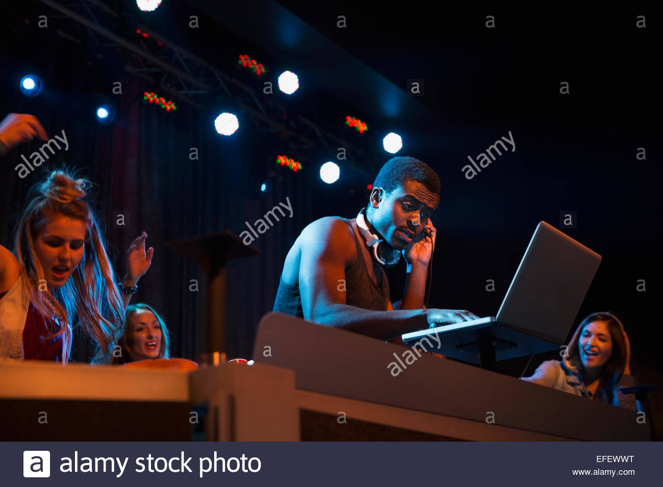DJ at laptop on stage in nightclub Stock Photo - Alamy
