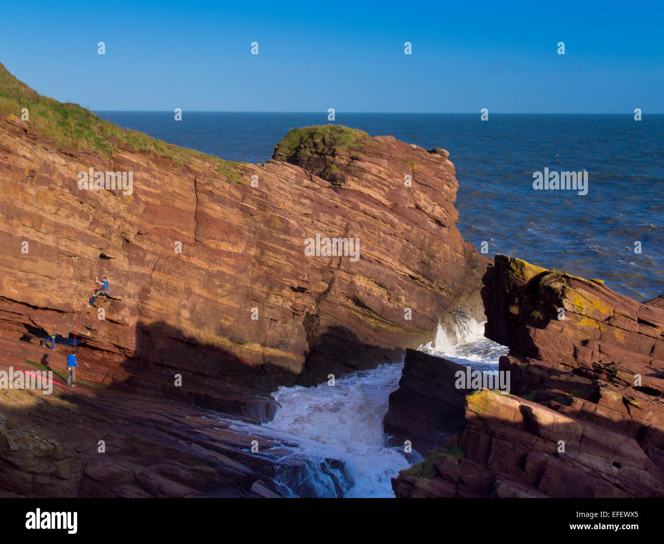 Men absailing down the steep sandstone cliffs at the Seaton Cliffs near ...