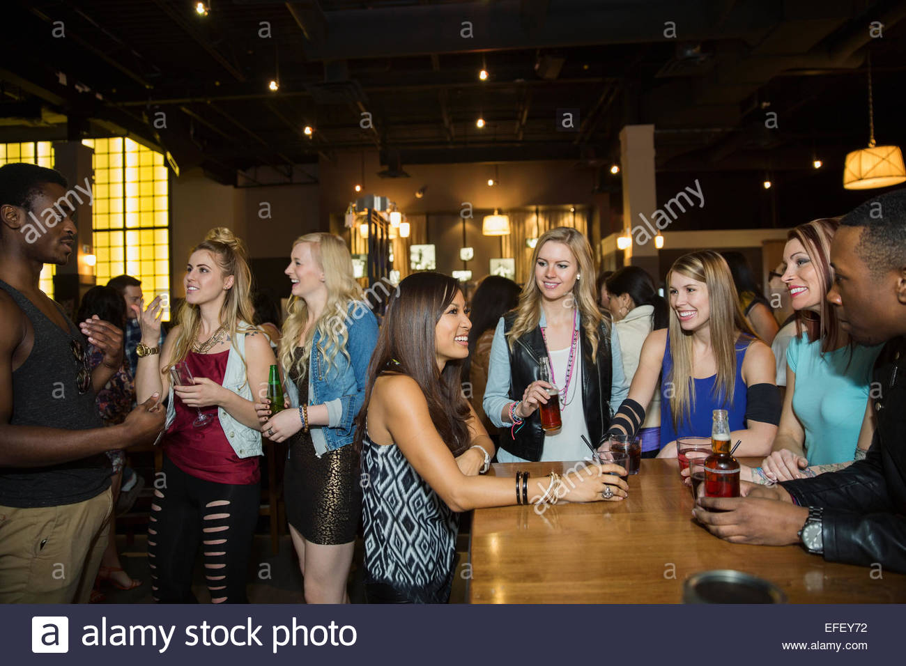 Friends talking and drinking at bar Stock Photo - Alamy