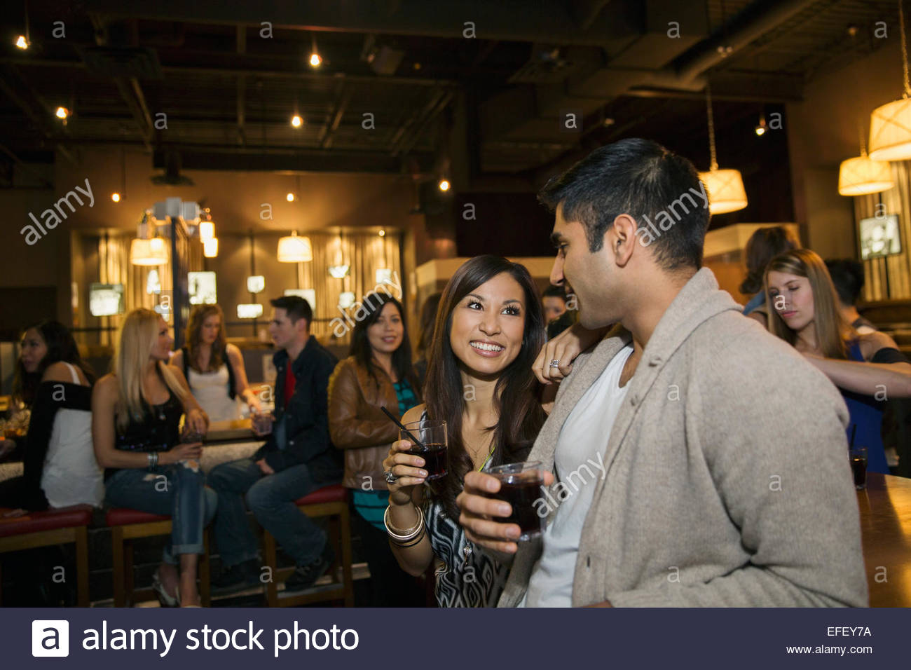Couple talking at bar standing holding drink hi-res stock photography ...