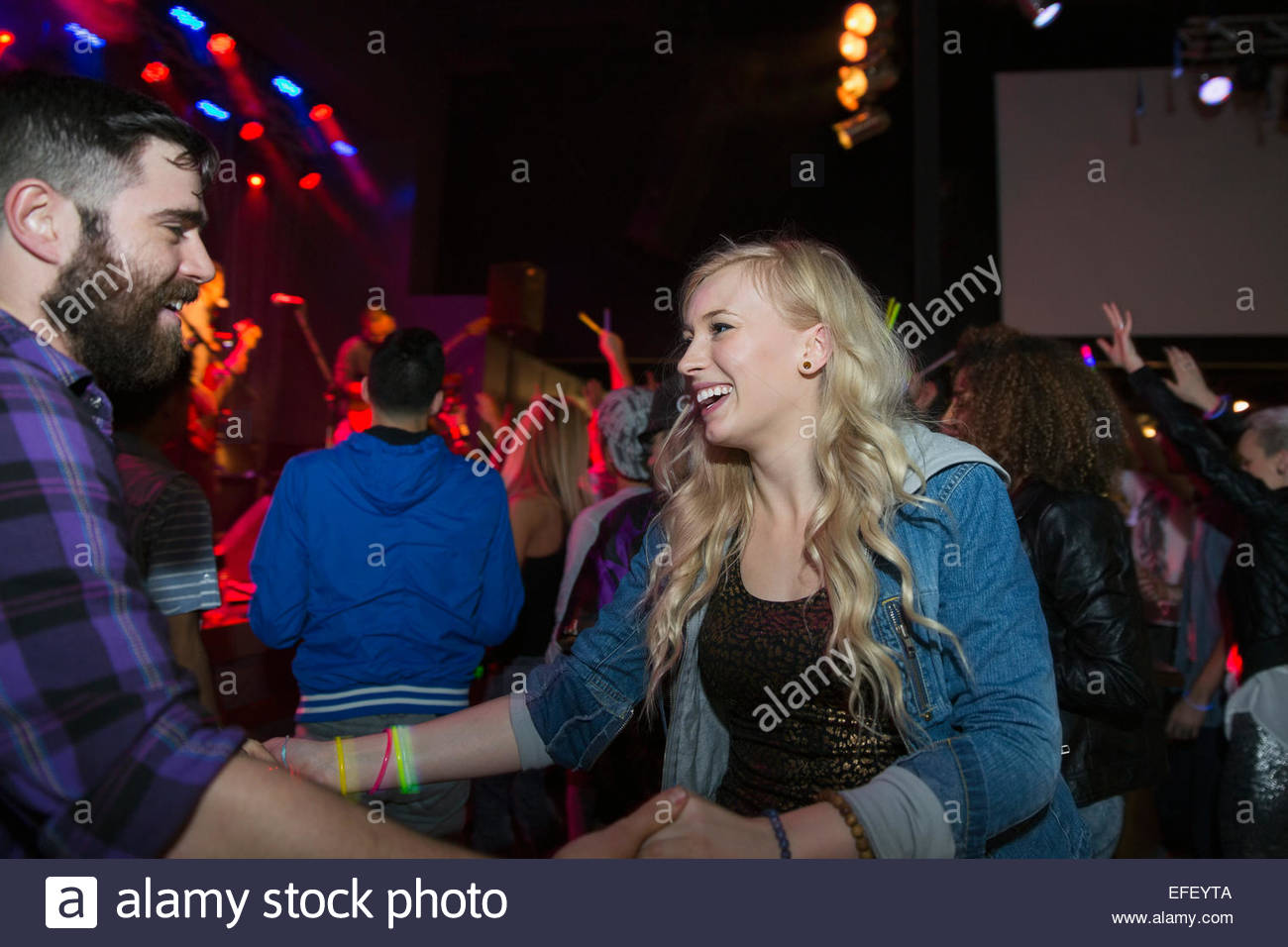 Couple holding hands and dancing at music concert Stock Photo - Alamy