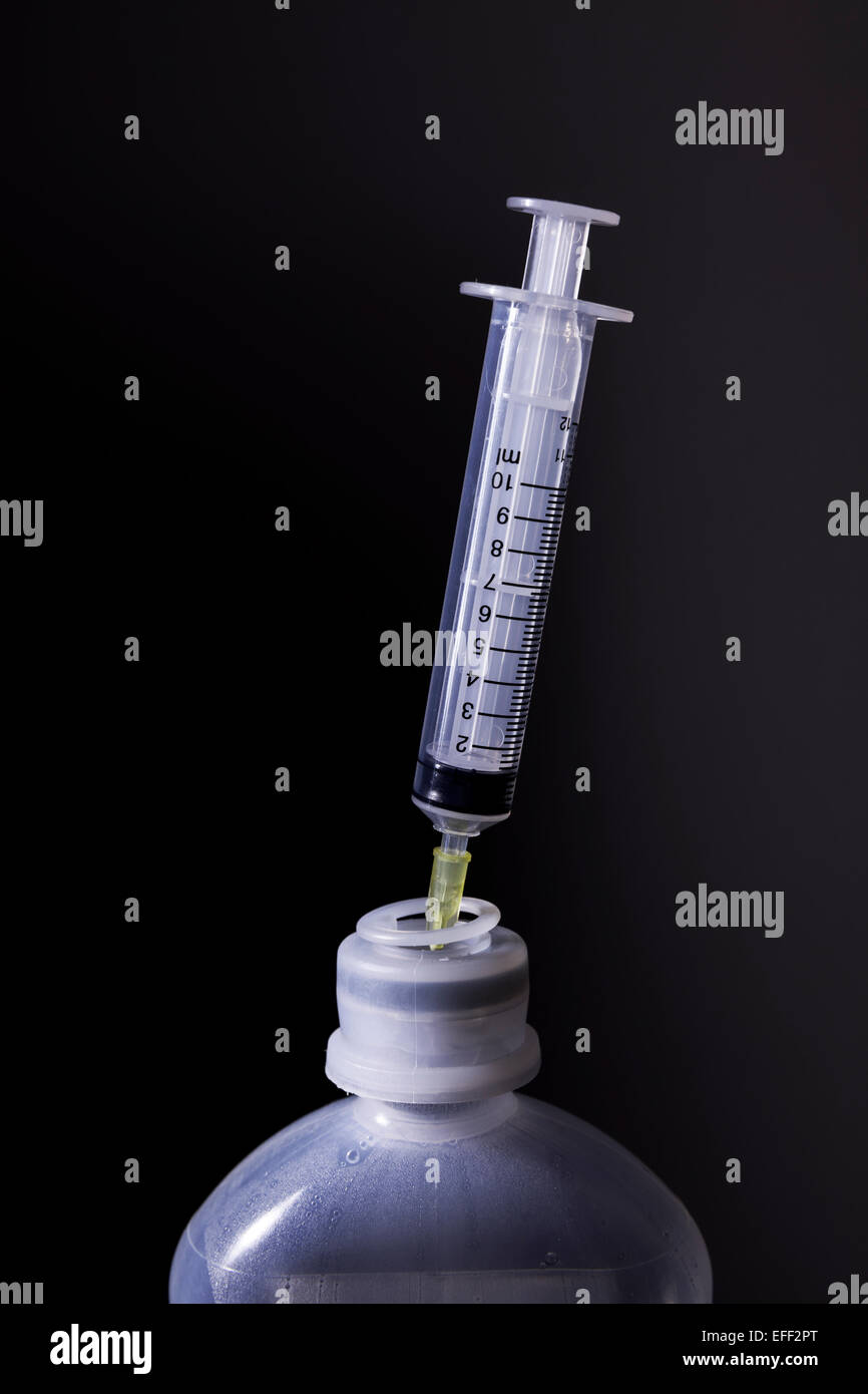 plastic syringes on bottle dark background Stock Photo - Alamy