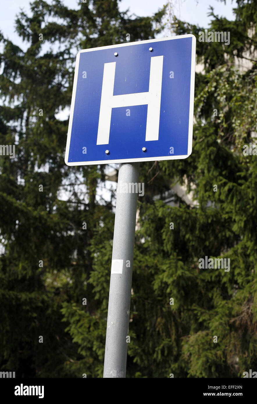 Hospital this way traffic sign above green background. A blue road sign ...