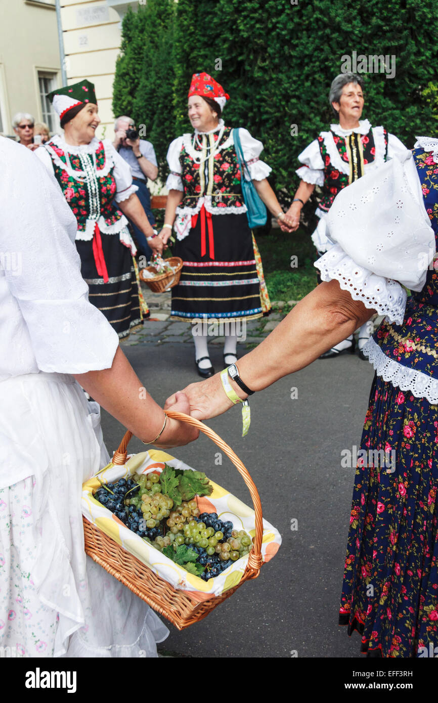 Women in traditional costumes with baskets of grapes dancing in circles ...