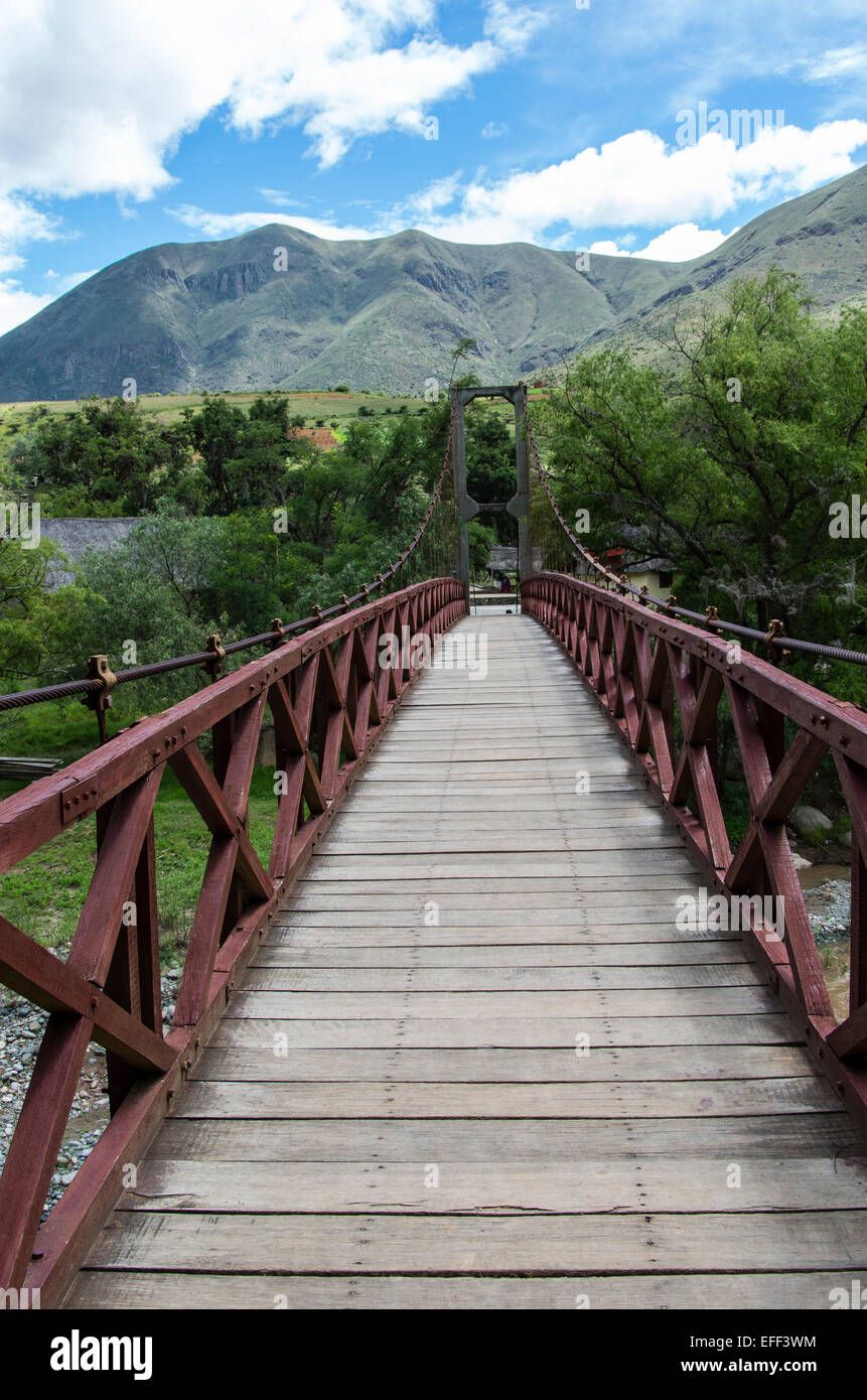 Pedestrian bridge in the upper Huallaga river. Andes mountains range ...