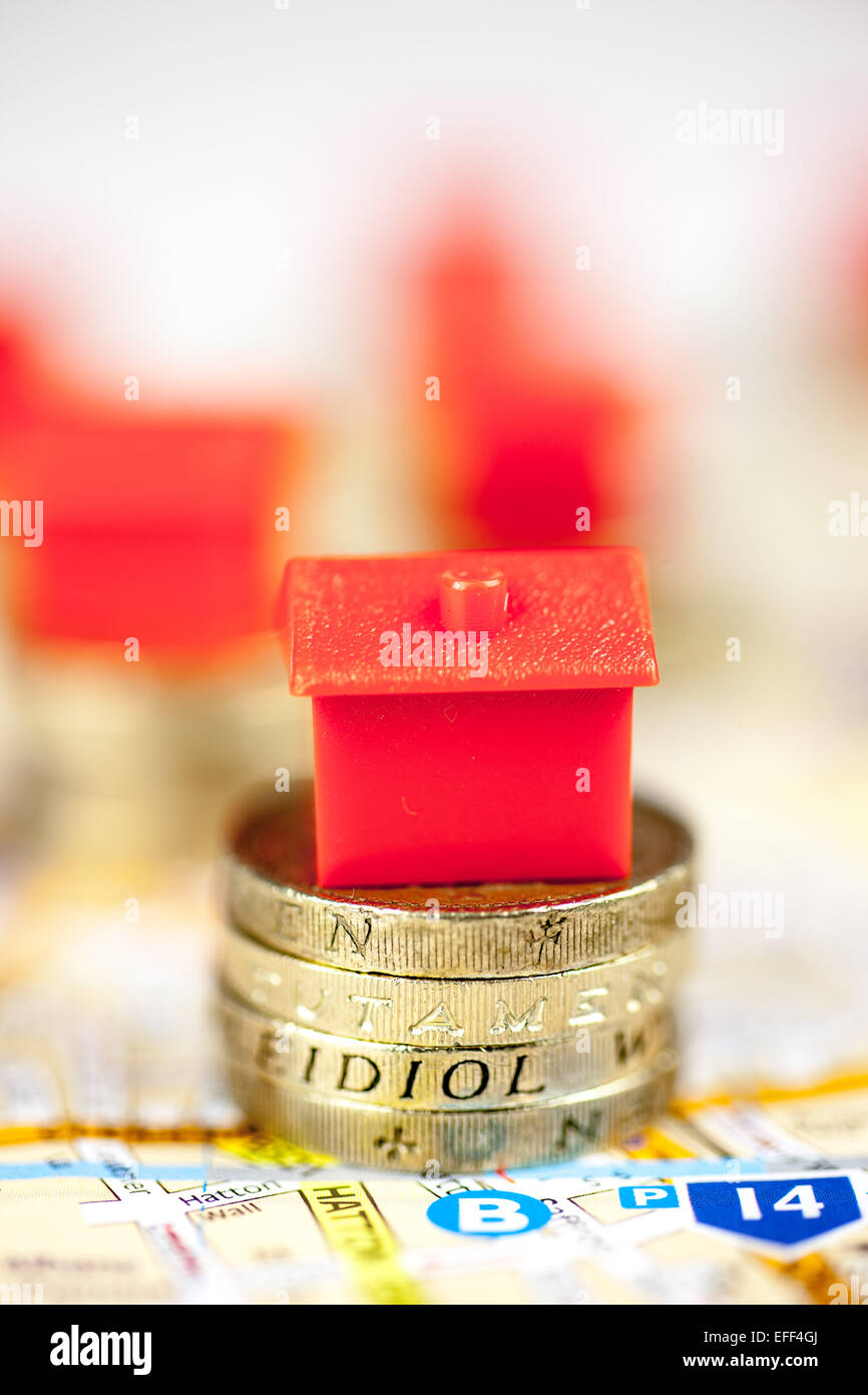 Red monopoly houses on top of piles of pound coins Stock Photo - Alamy