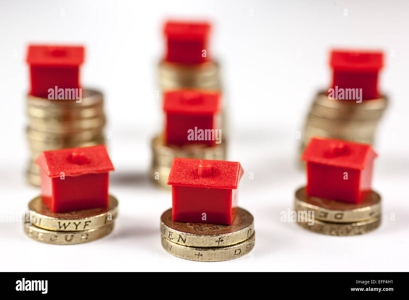 Red monopoly houses on top of piles of pound coins Stock Photo - Alamy