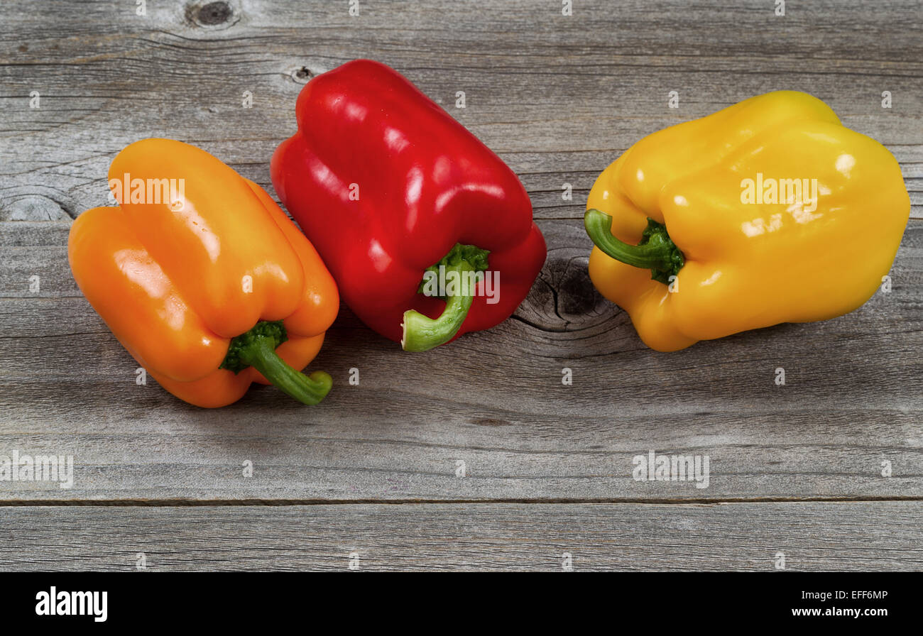 Three fresh bell peppers on aged wood Stock Photo - Alamy