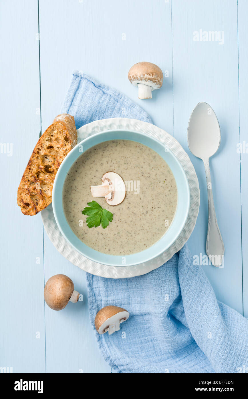 Creme of mushroom soup in light blue soup bowl, baguette slice Stock ...