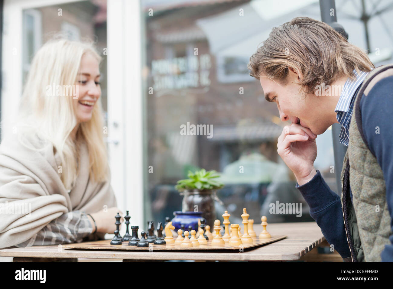 Happy couple playing chess at cafeteria backyard Stock Photo - Alamy