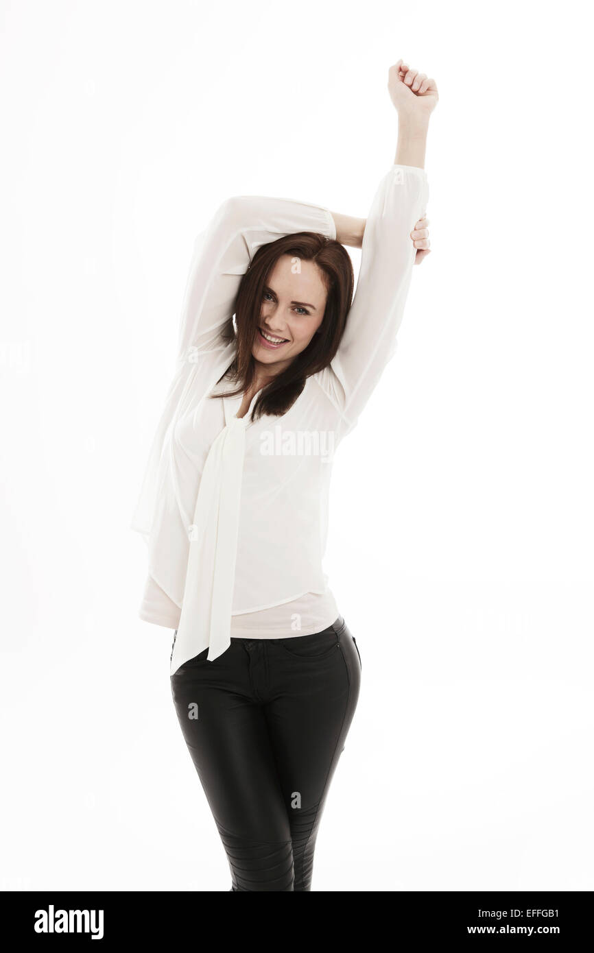 Portrait of successful young woman with outstretched arm in front of ...