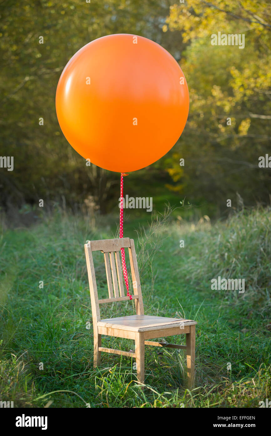 Chair with balloon on meadow Stock Photo - Alamy