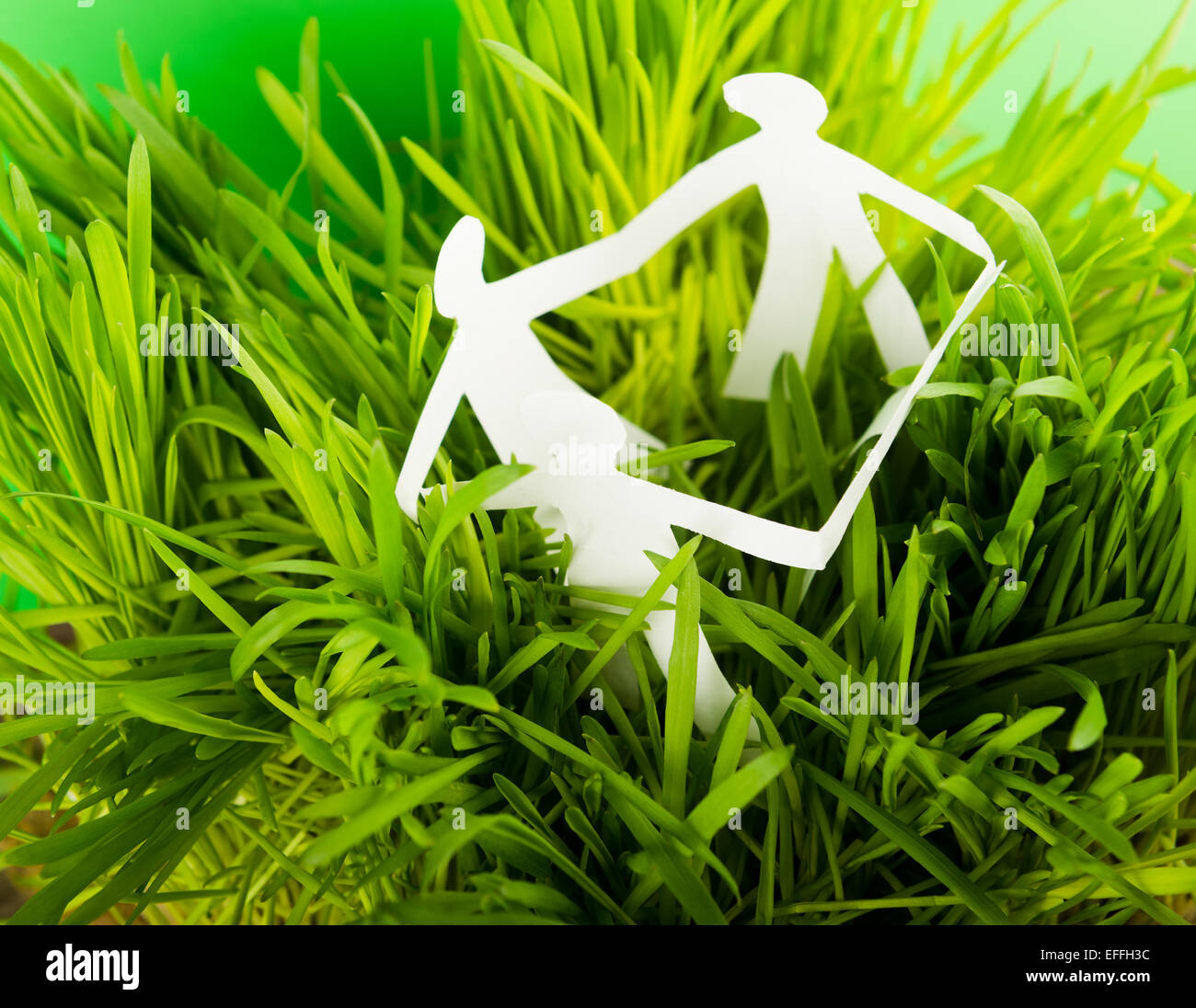 Paper people on green grass on bright background Stock Photo - Alamy