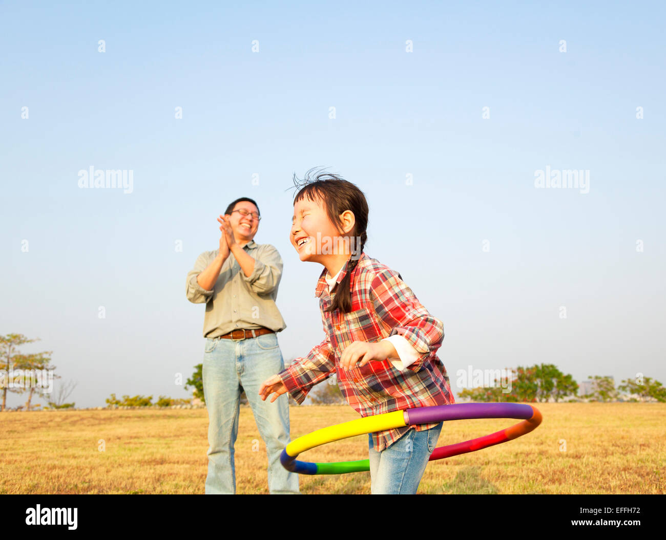 happy little girl playing hula hoops outdoors Stock Photo - Alamy