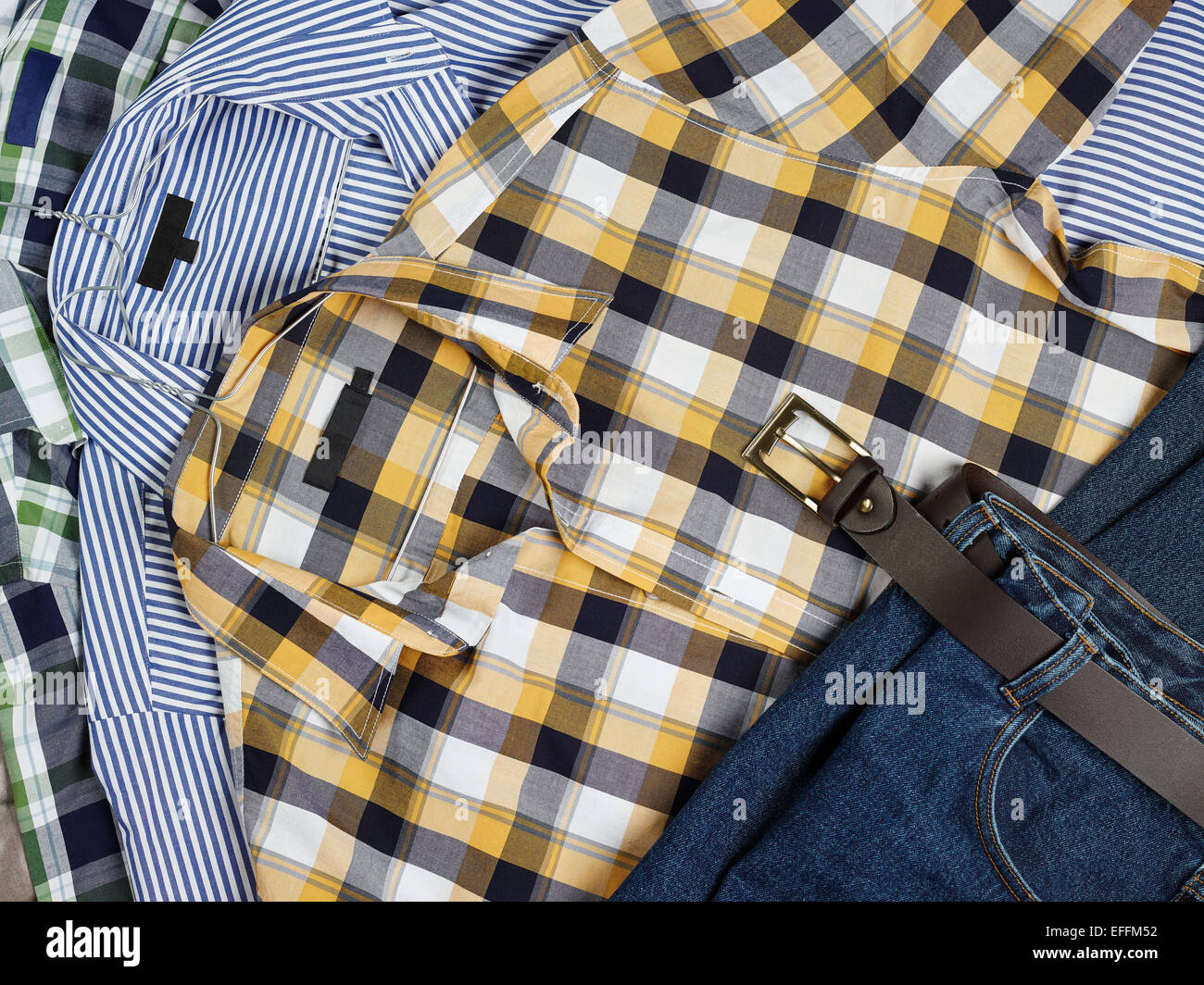Close up, men's casual patterned shirts and jeans in the same stack ...