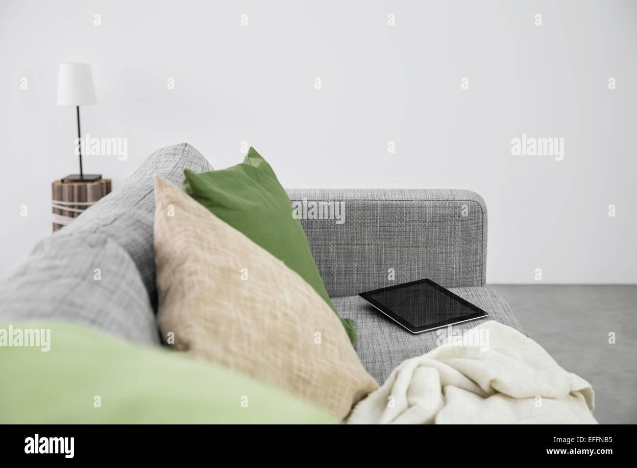 Digital tablet lying on couch in a modern living room Stock Photo - Alamy