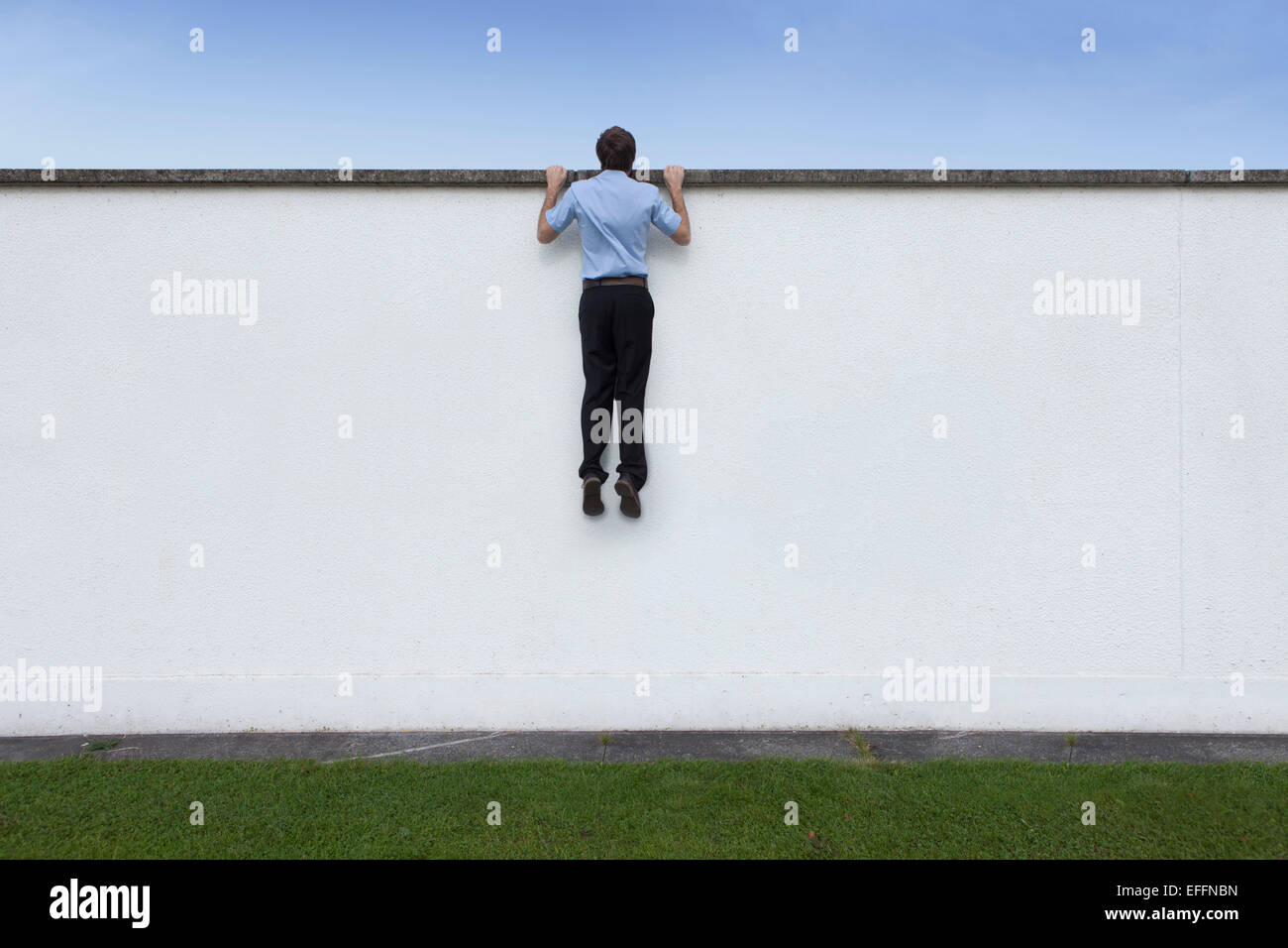 Business man looking over wall Stock Photo - Alamy