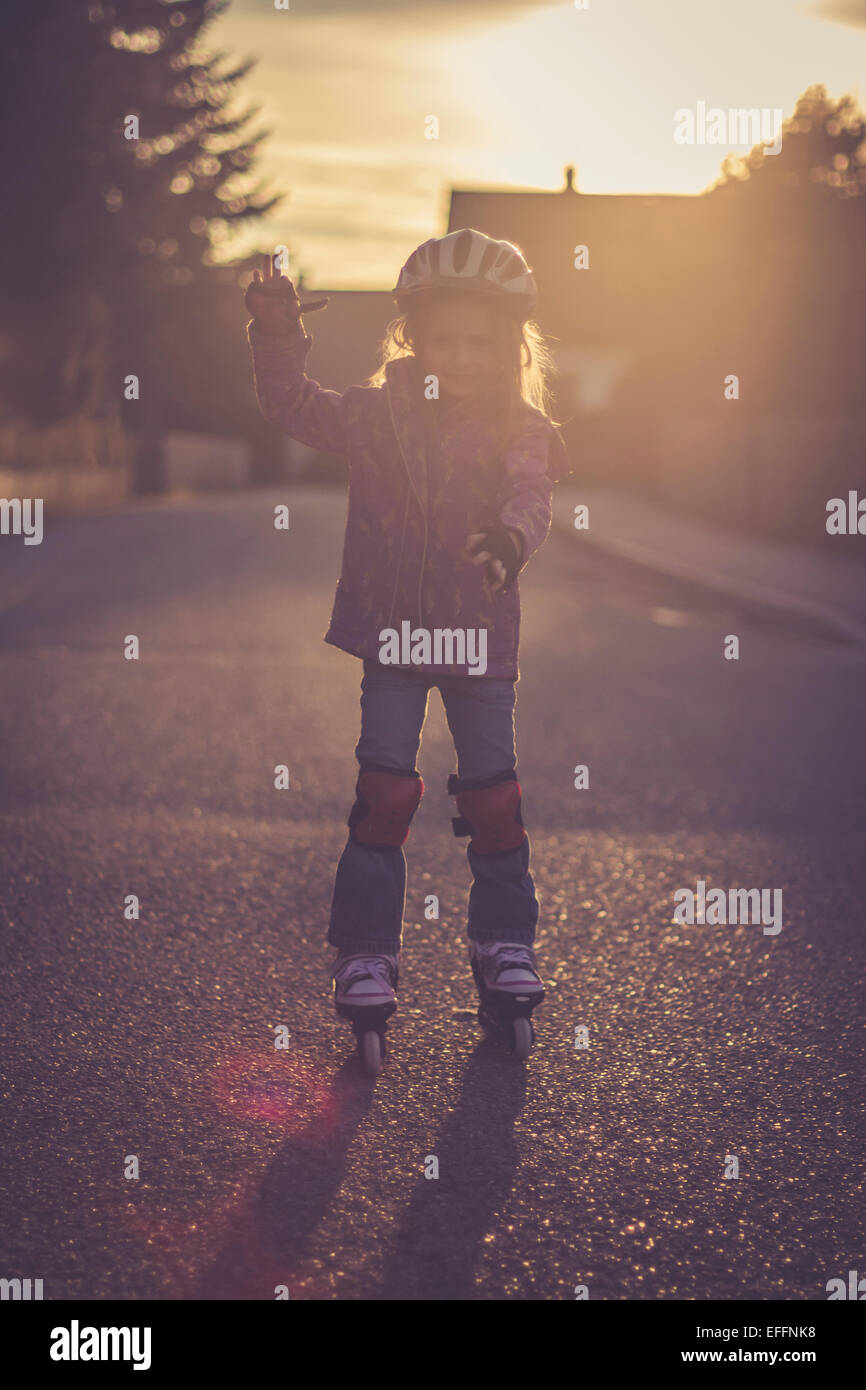 Little girl balancing on rollerblades at backlight Stock Photo - Alamy