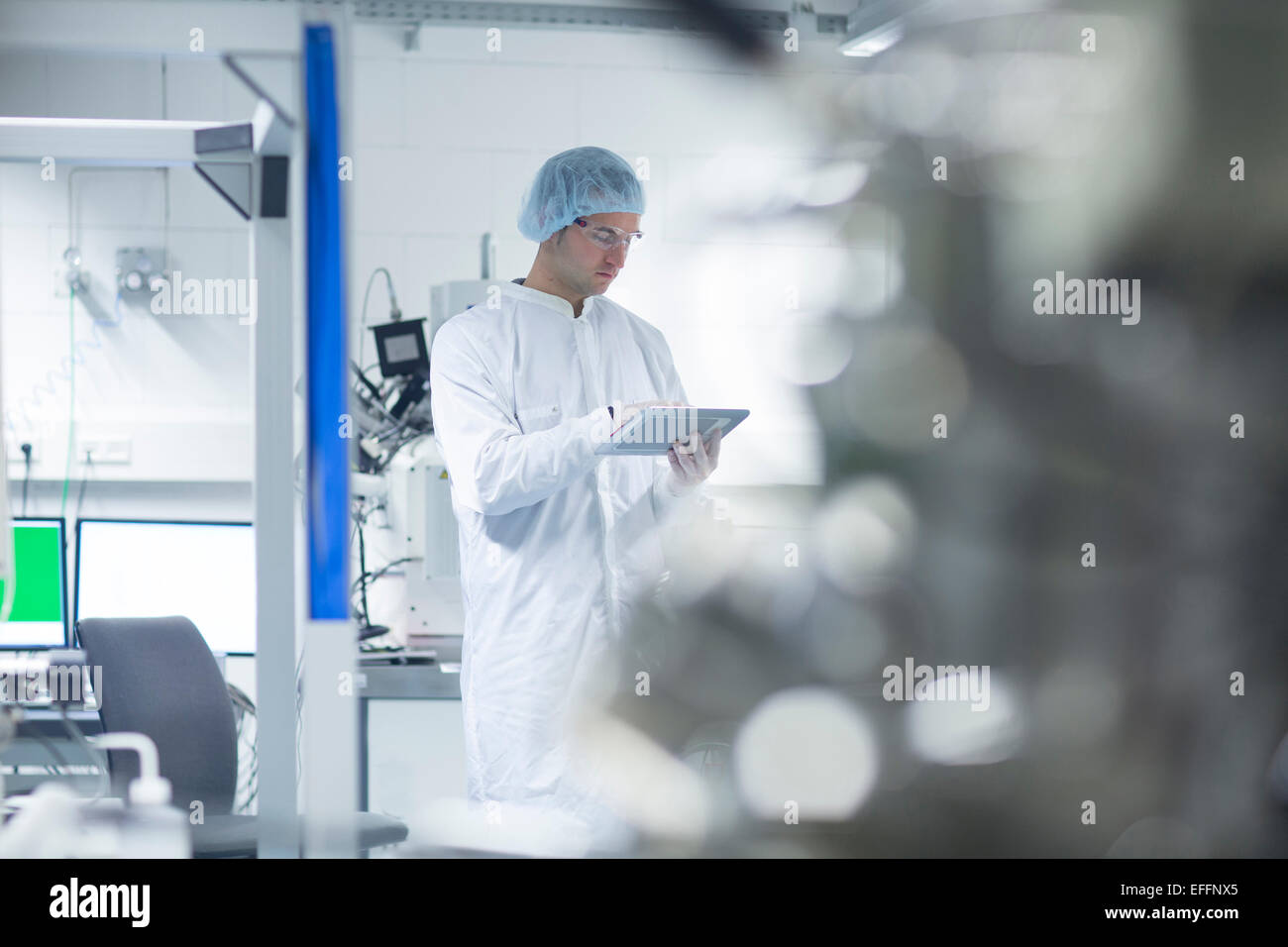 Technician in cleanroom holding digital tablet Stock Photo - Alamy