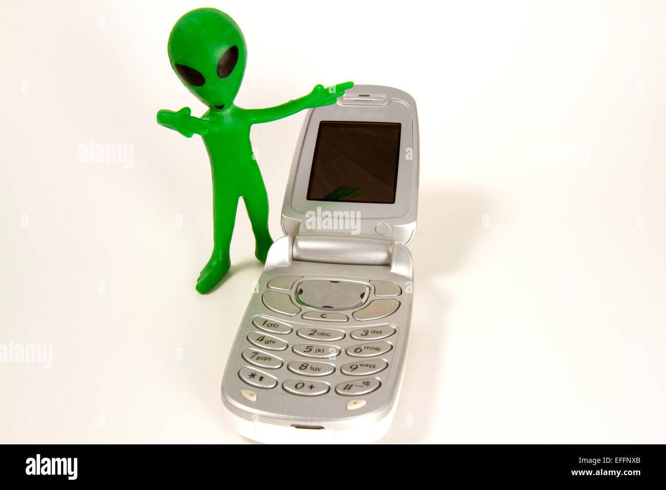 Little green alien making a Call Me gesture pointing to a cell phone ...
