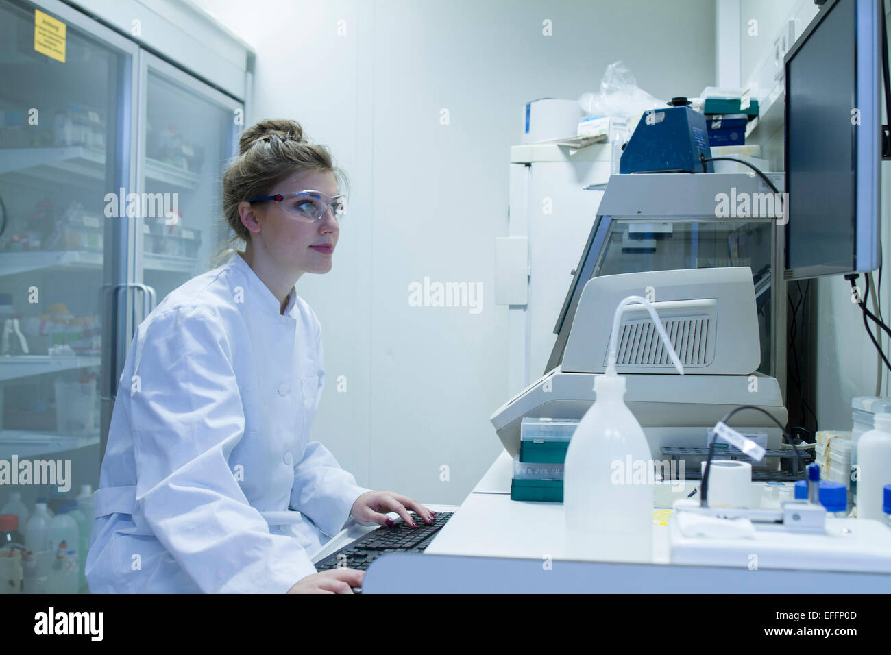Biologist in laboratory working at computer Stock Photo - Alamy