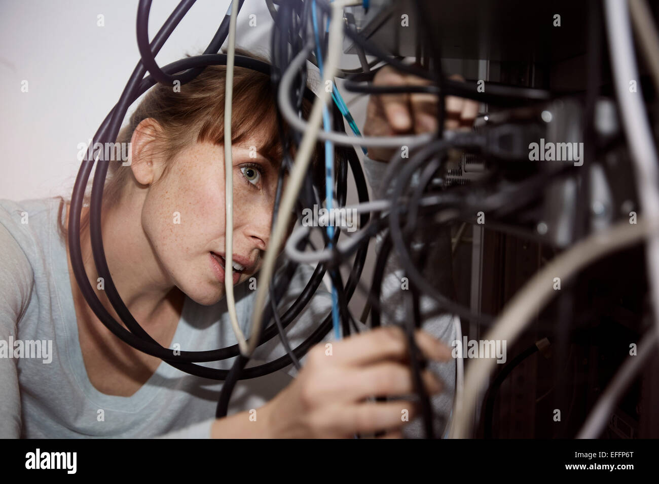 Woman with tangled cables Stock Photo - Alamy