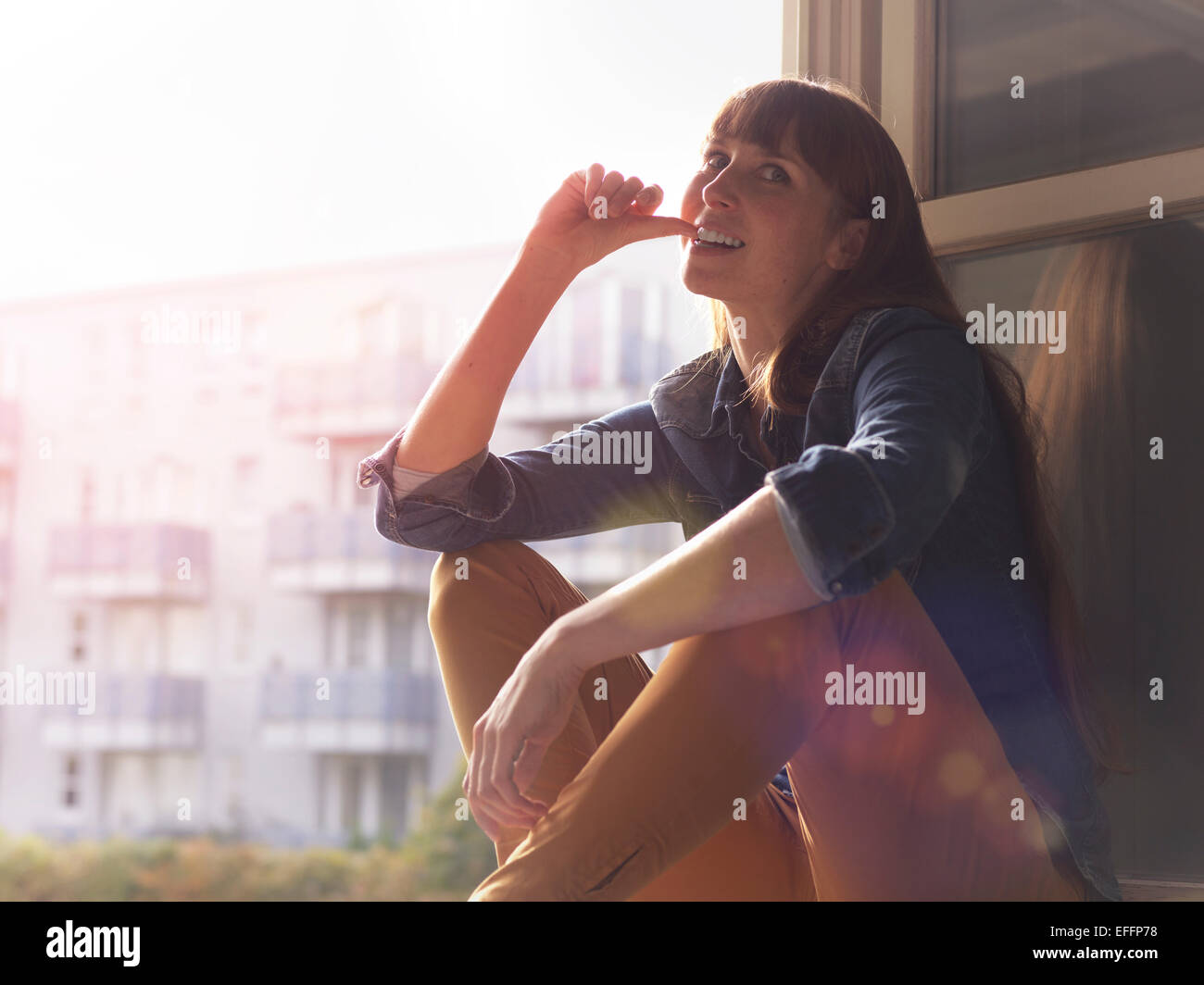 Smiling woman at open window Stock Photo - Alamy
