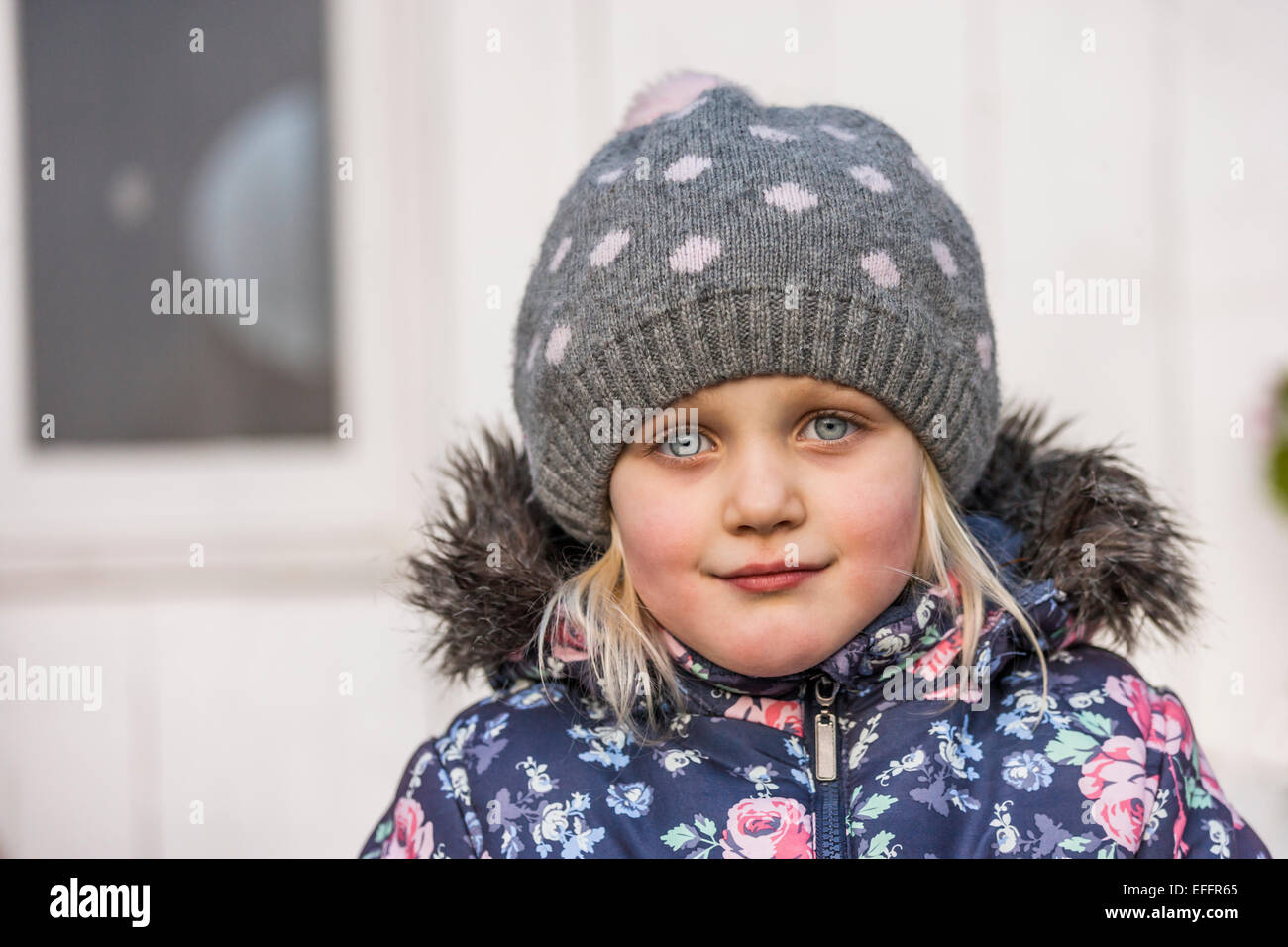 Portrait of little girl wearing wool cap and winter jacket Stock Photo ...