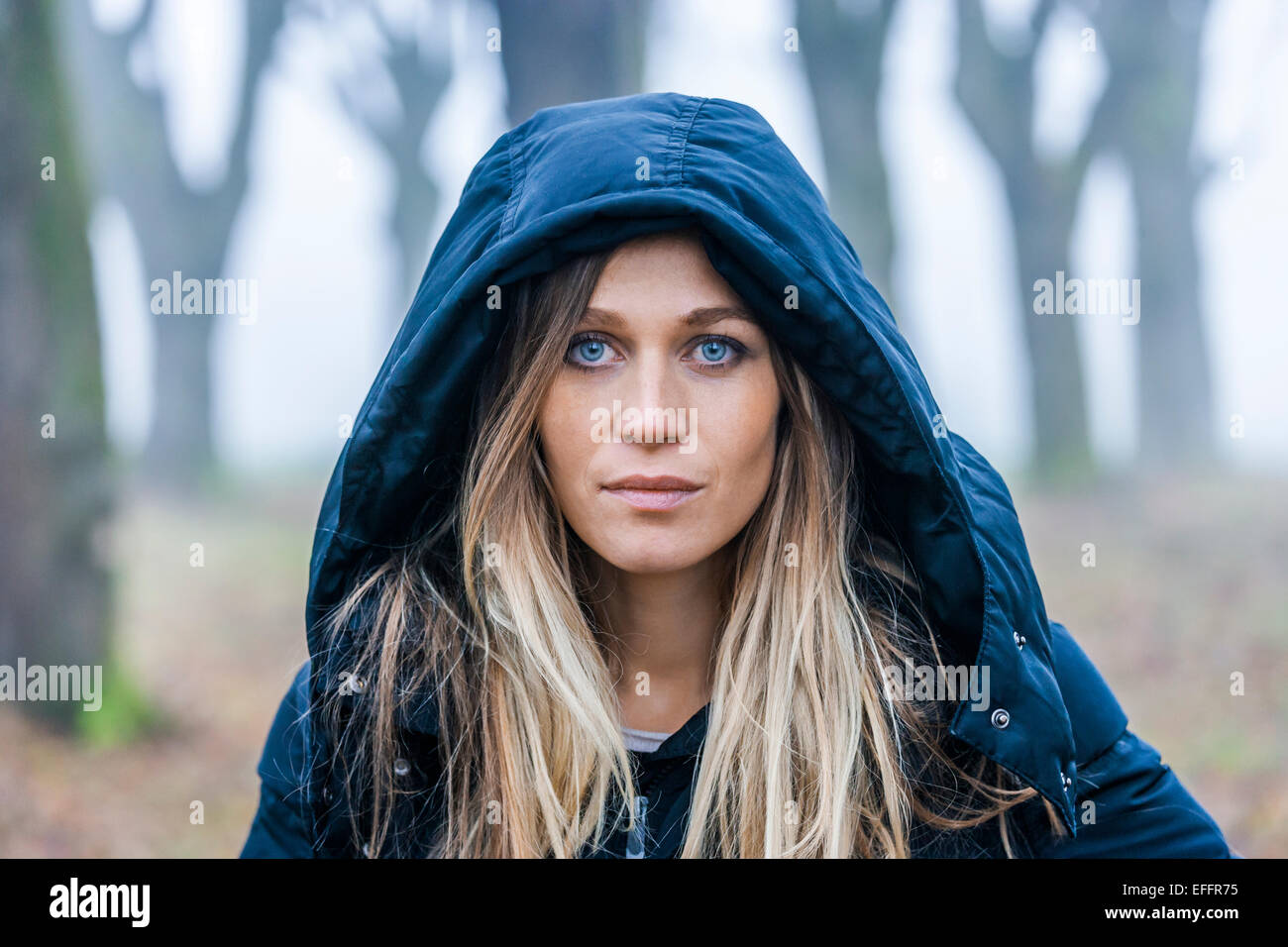Portrait of serious looking blond woman with blue hood Stock Photo - Alamy