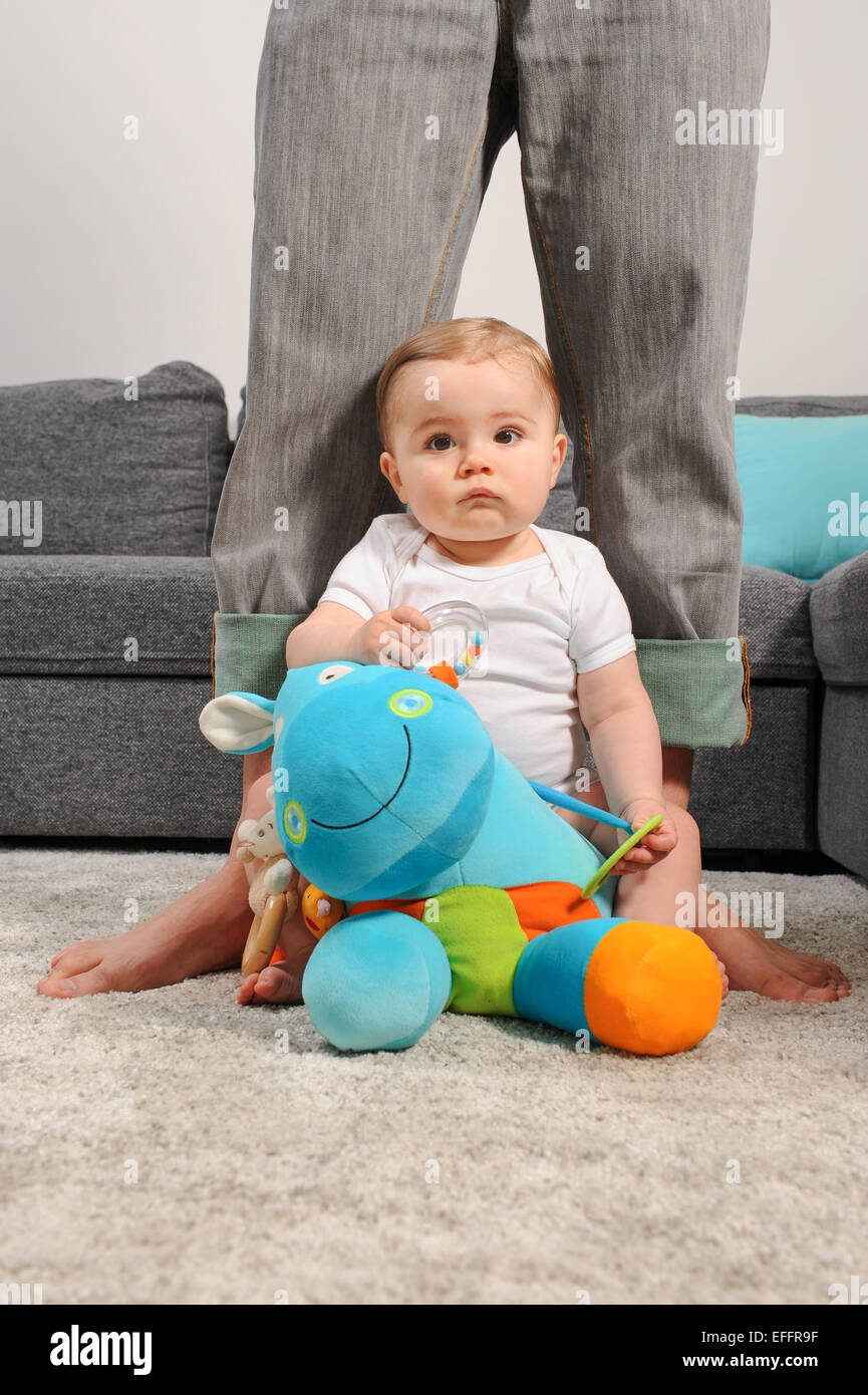 Dad and newborn baby sitting on a carpet Stock Photo - Alamy