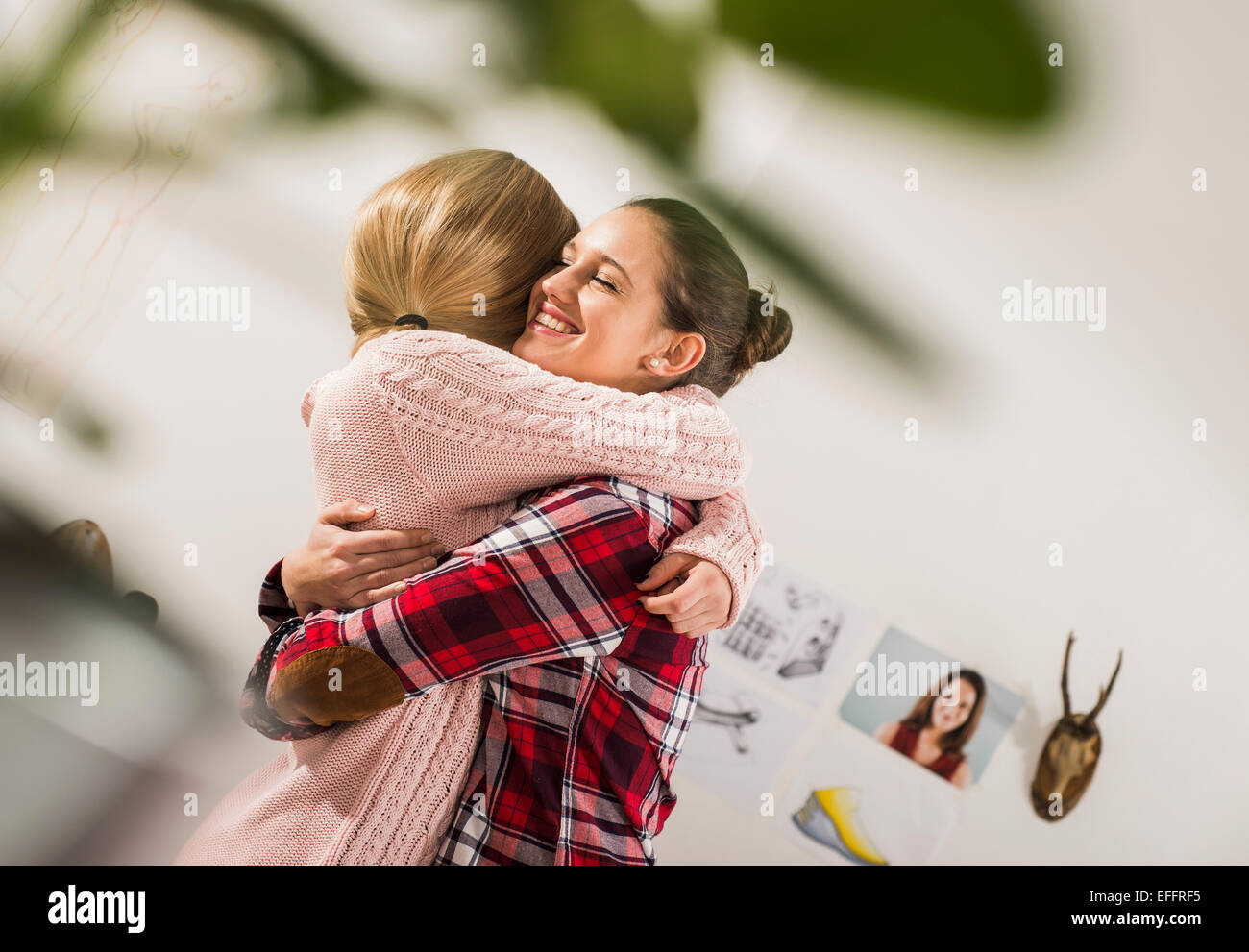 Two happy female friends embracing at home Stock Photo - Alamy