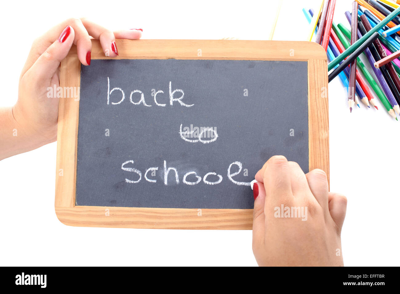 a girl writing back to school on blackboard Stock Photo - Alamy