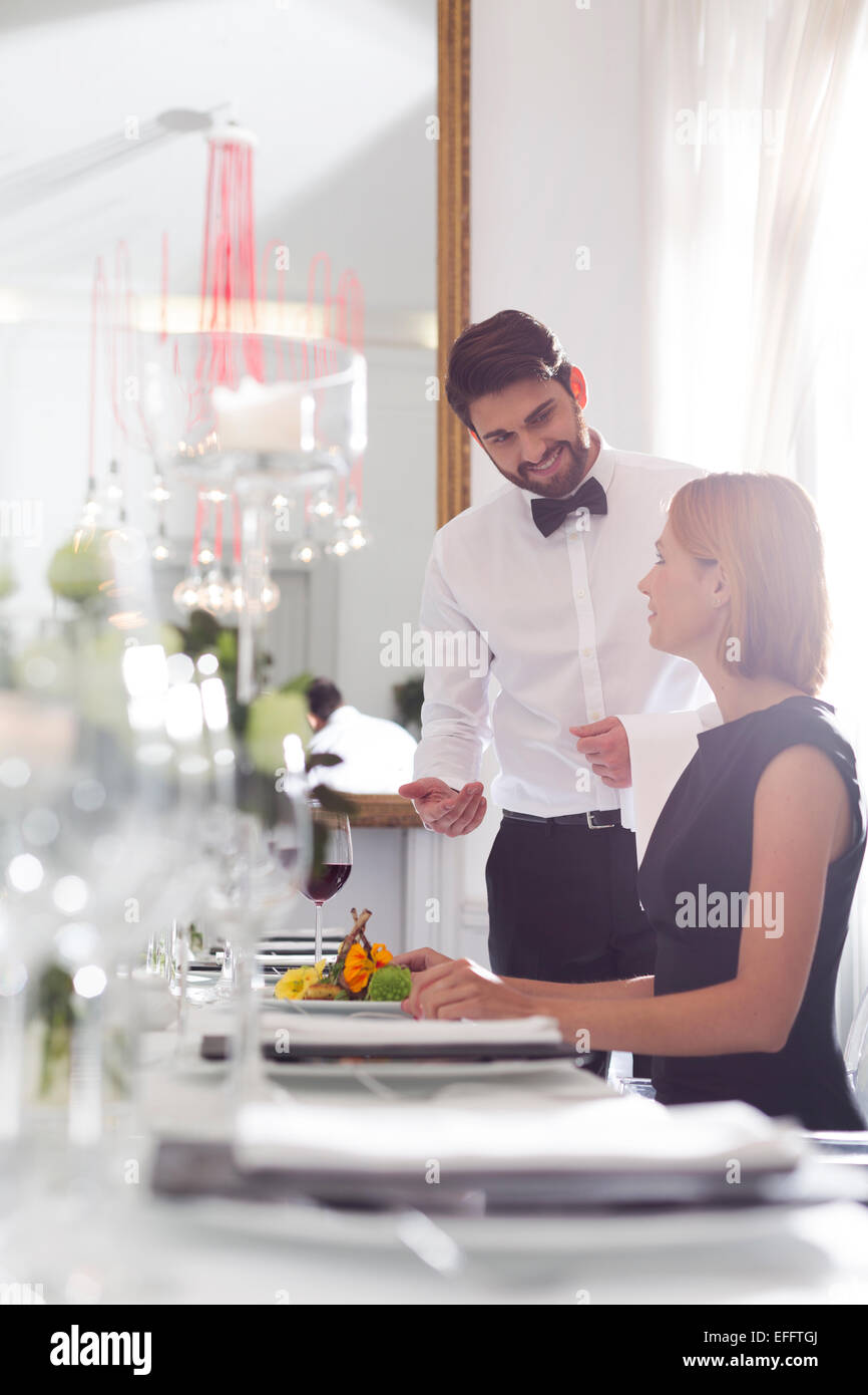 Waiter serving dinner to woman in elegant restaurant Stock Photo - Alamy