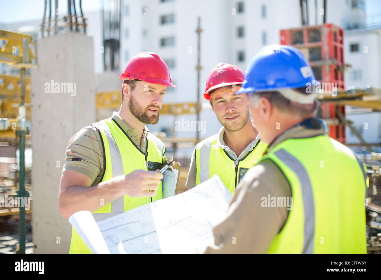 Construction workers discussing building plans in construction site ...