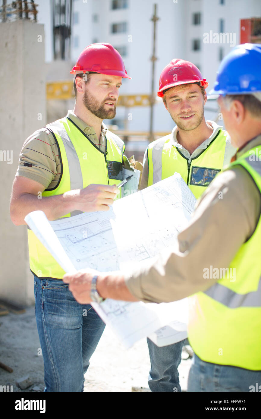 Construction workers discussing building plans in construction site ...