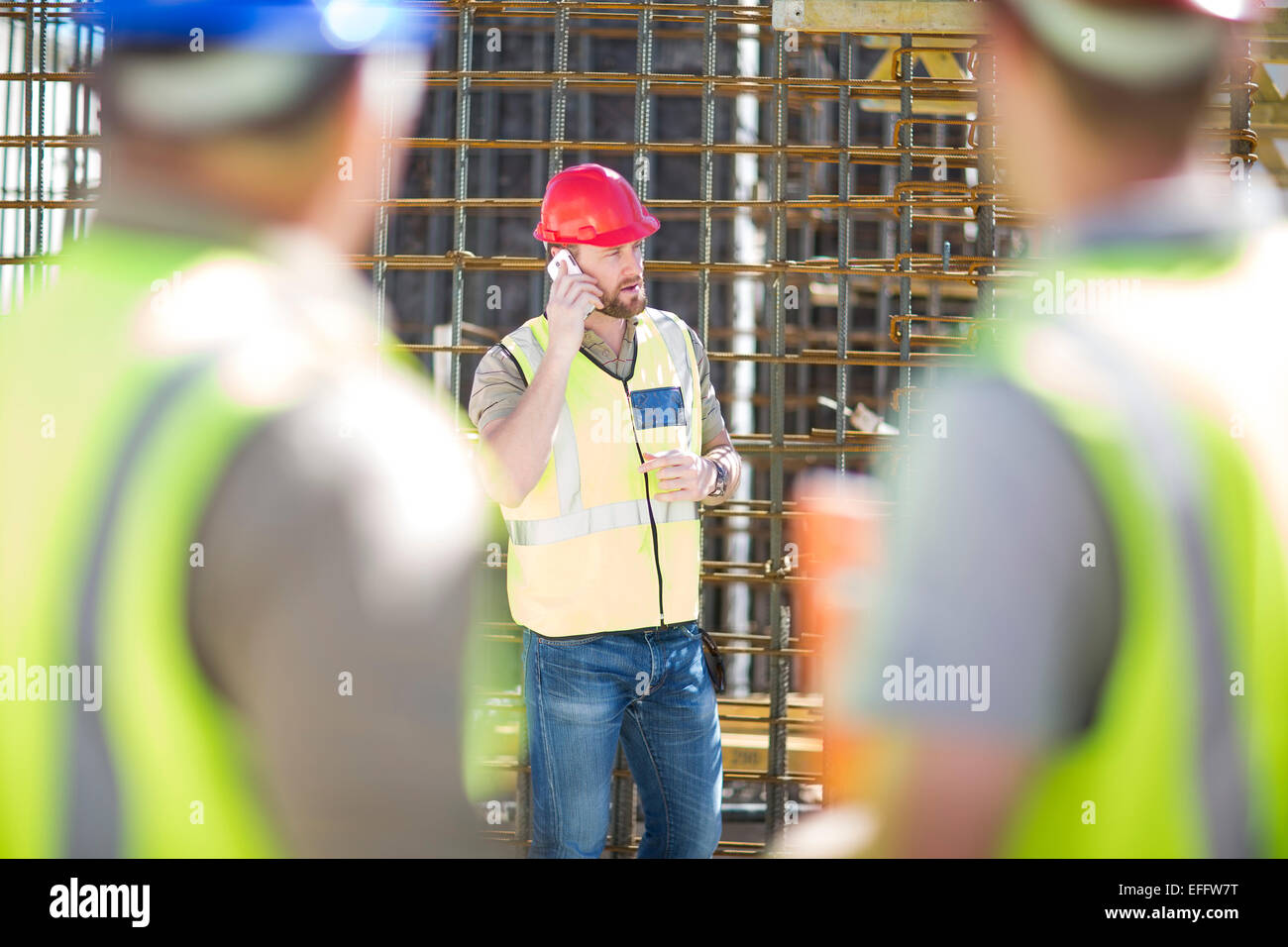 Construction worker on cell phone in construction site Stock Photo - Alamy