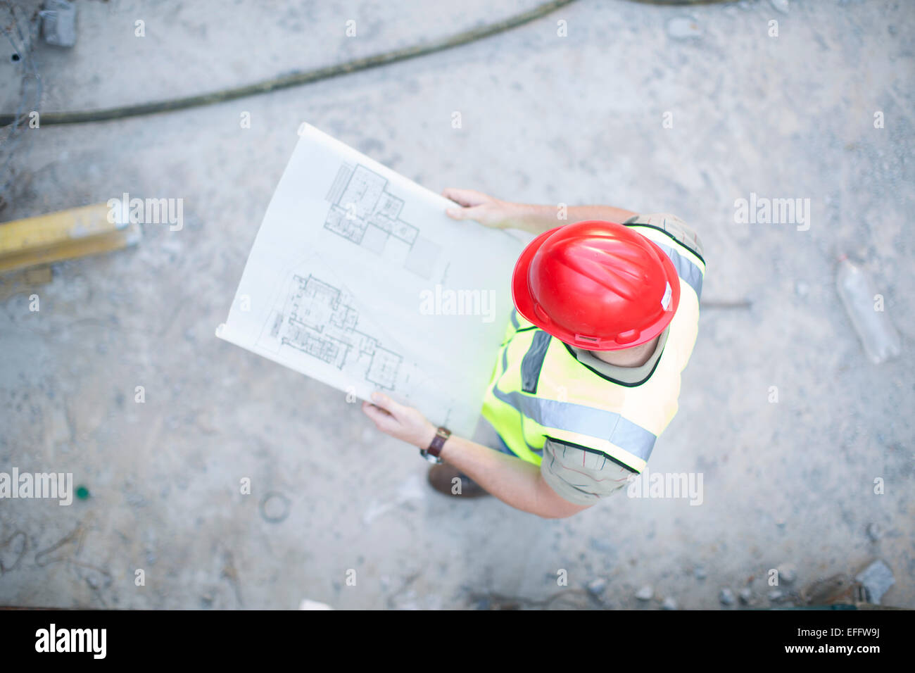 Construction worker reading plan at construction site Stock Photo - Alamy