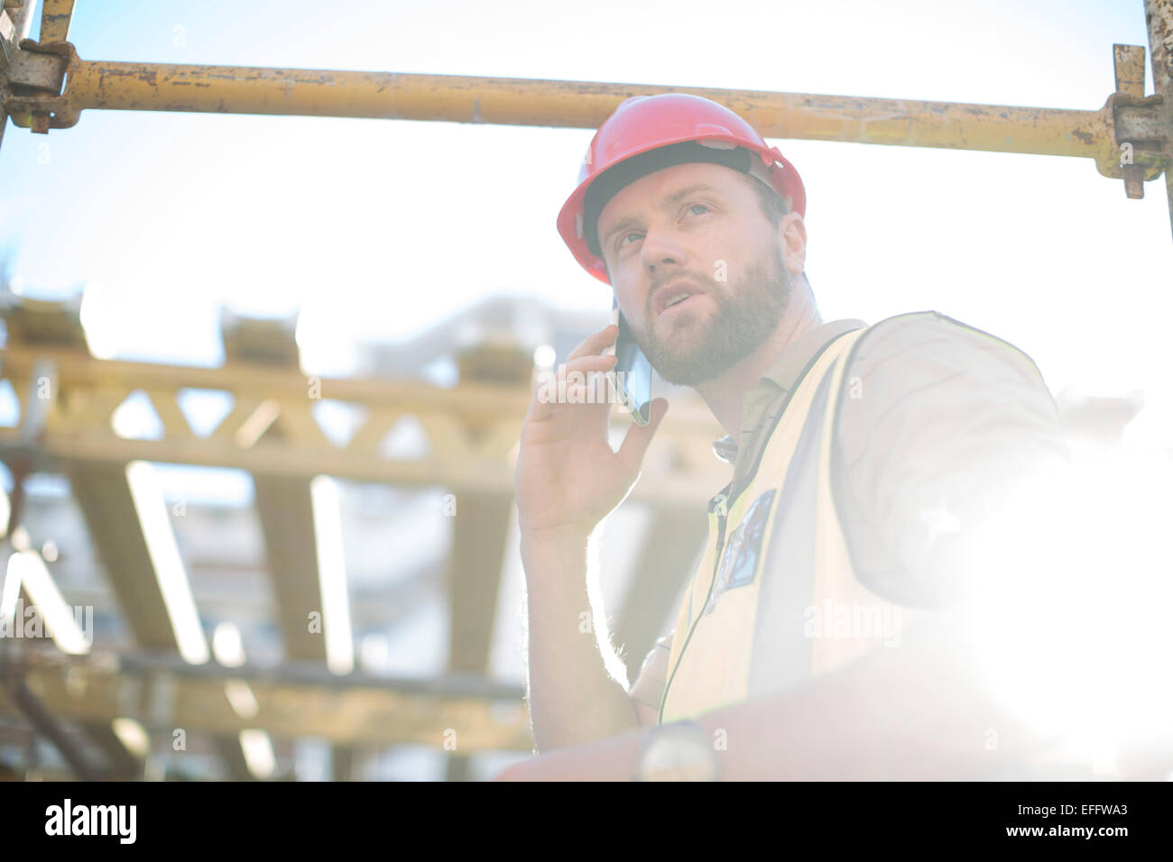 Construction worker on cell phone on construction site Stock Photo - Alamy