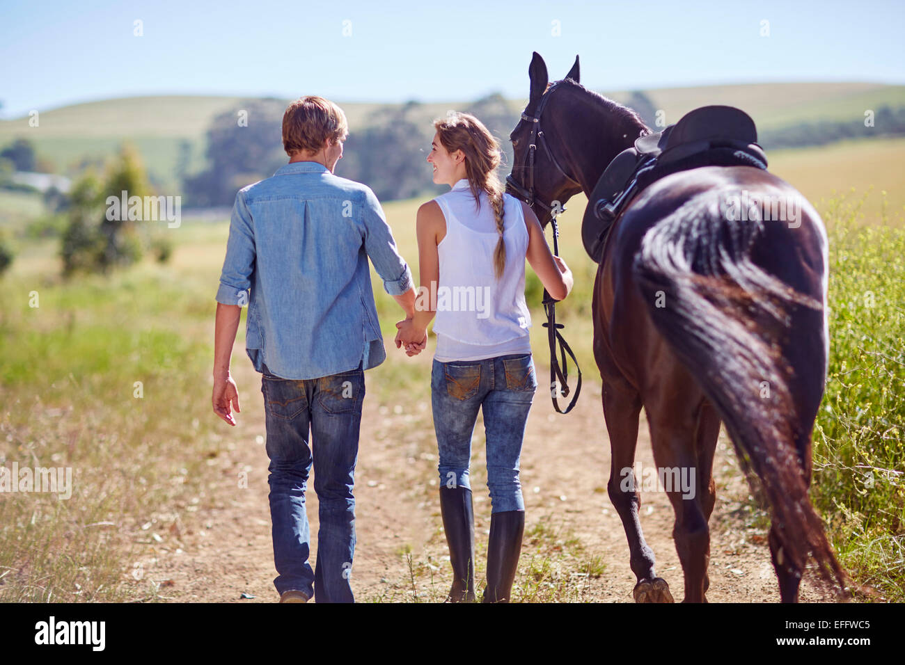 Young couple walking with horse on the countryside Stock Photo - Alamy