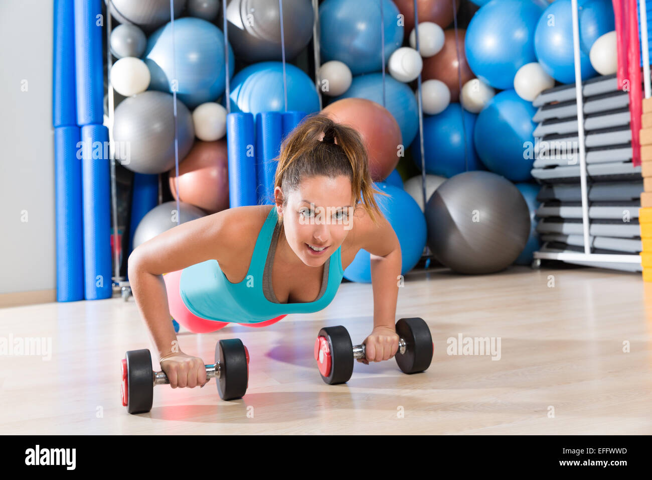 Girl at gym push-up strength pushup exercise with dumbbells workout ...