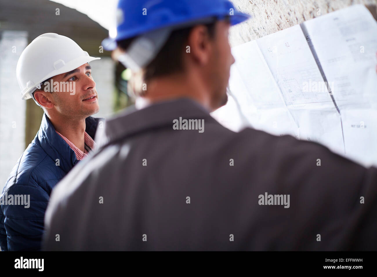 Construction workers discussing building plans Stock Photo - Alamy
