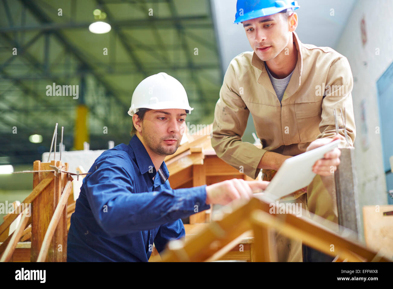 Construction worker and foreman discussing roof beams Stock Photo - Alamy