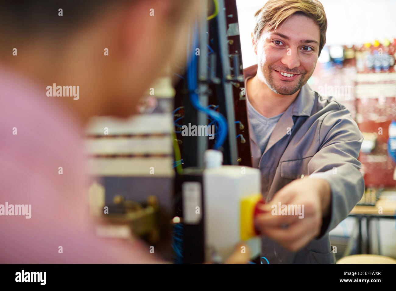 Smiling electrician operating machine Stock Photo - Alamy